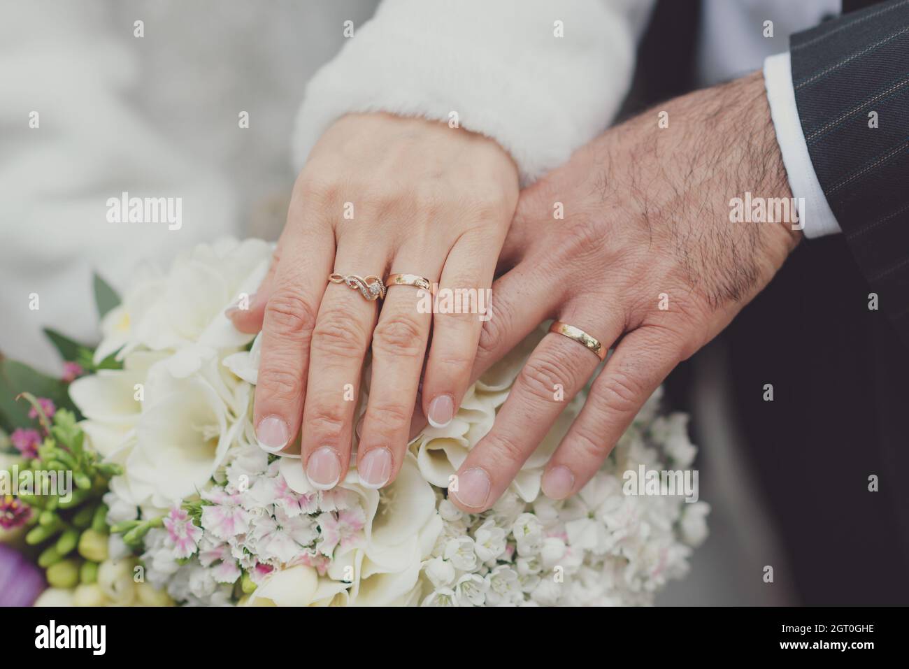 Bridal couple holding hands, showing wedding rings Stock Photo - Alamy