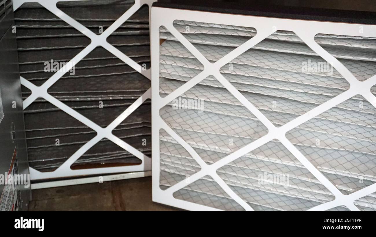 Changing out an old furnace air filter and replacing with a new clean ...