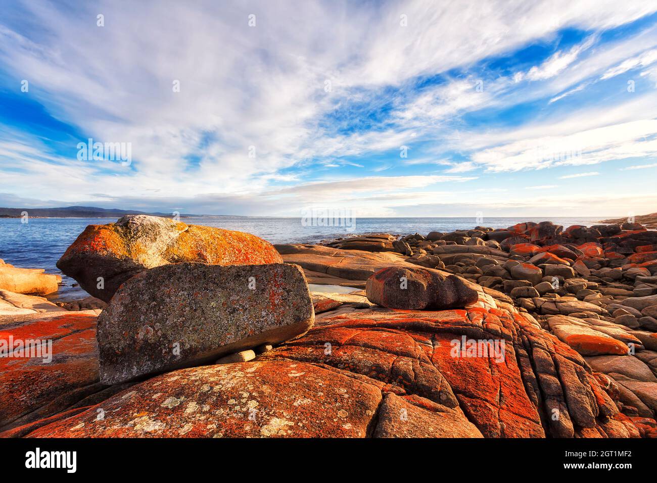 Red lichen boulder rocks in Binalong Bay of Fires on Tasmania Pacific ...