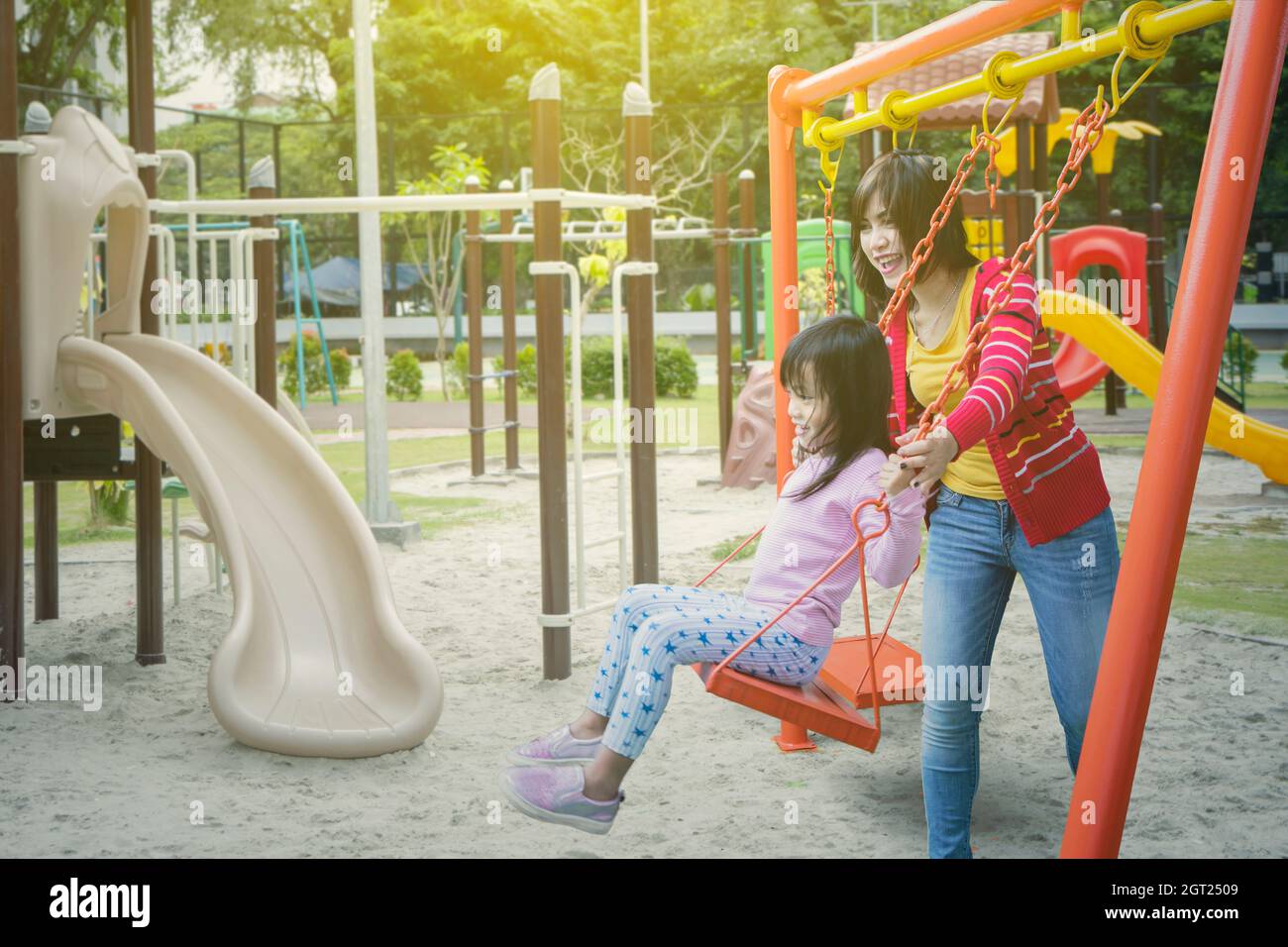 Childhood smiling sitting swinging leisure pushing fun hi-res stock photography and images - Alamy
