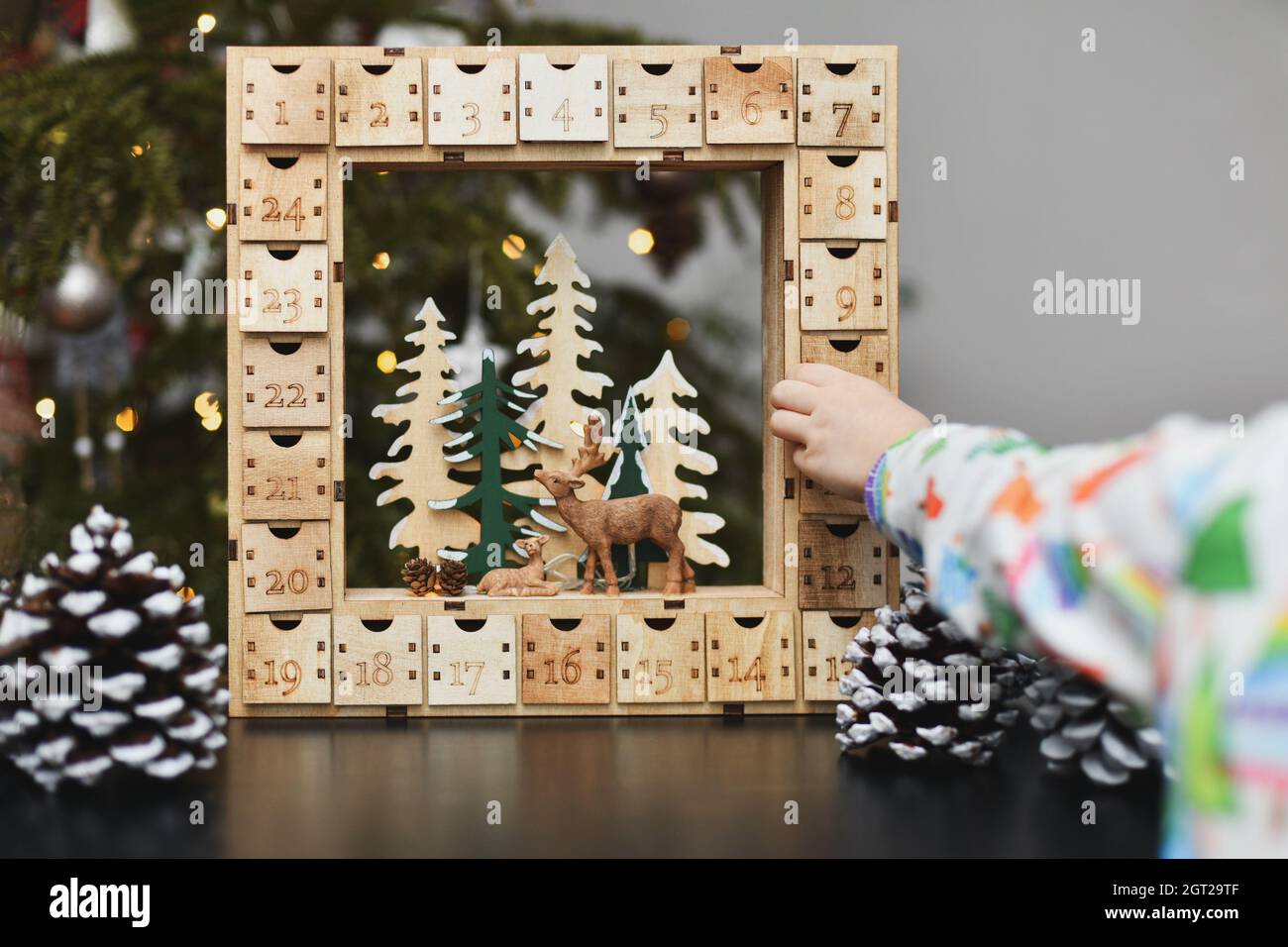Girl opens wooden advent calendar Stock Photo - Alamy