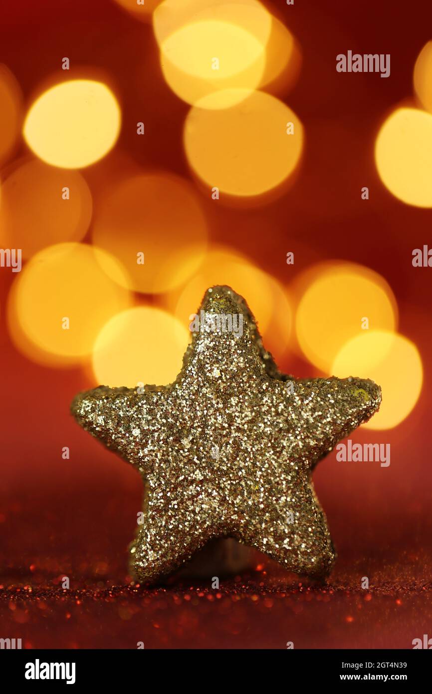 Christmas and New Years season. Shiny decorative star on glitter background with shining bokeh ...