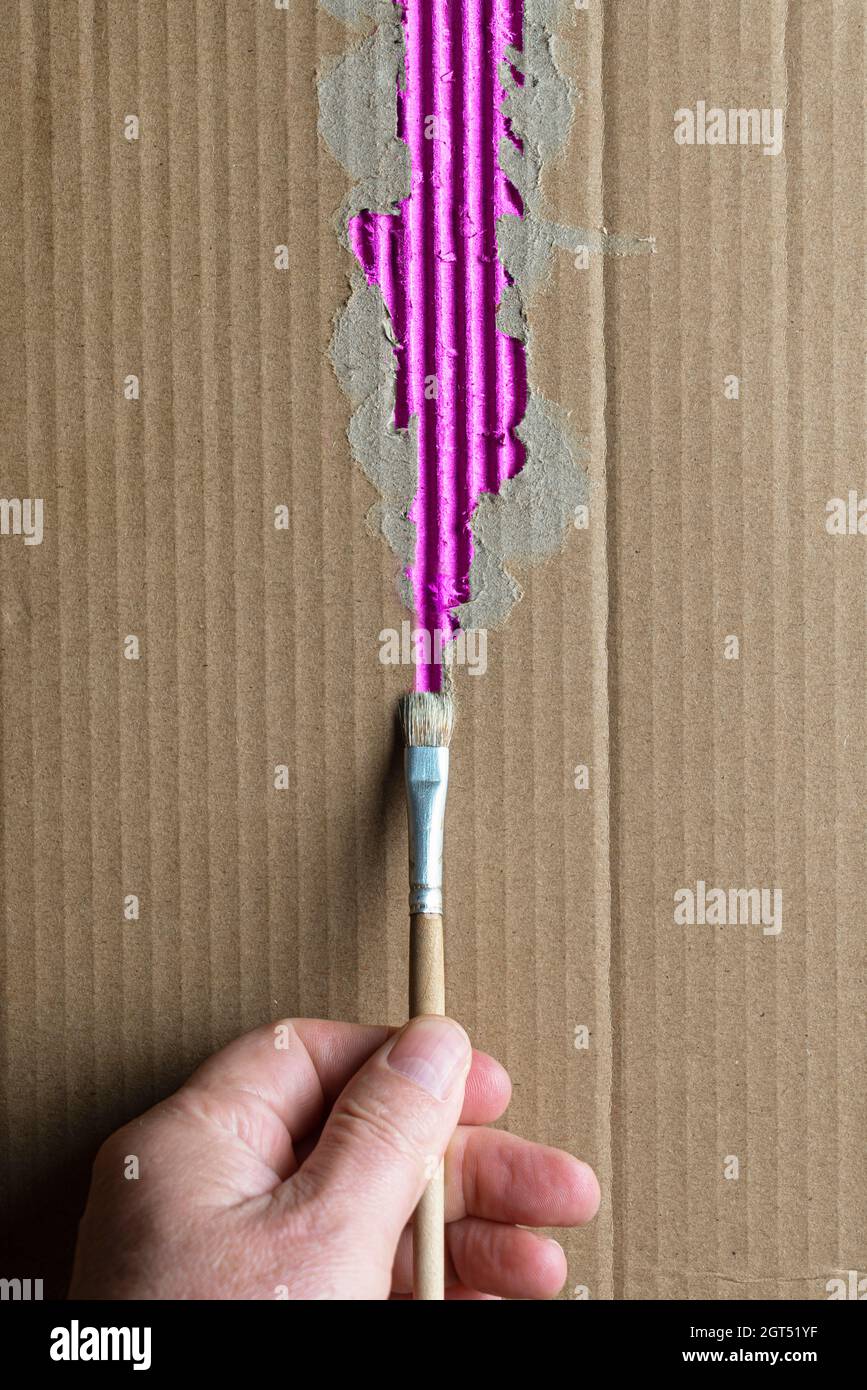 Paint A Torn Corrugated Cardboard With A Brush Stock Photo - Alamy