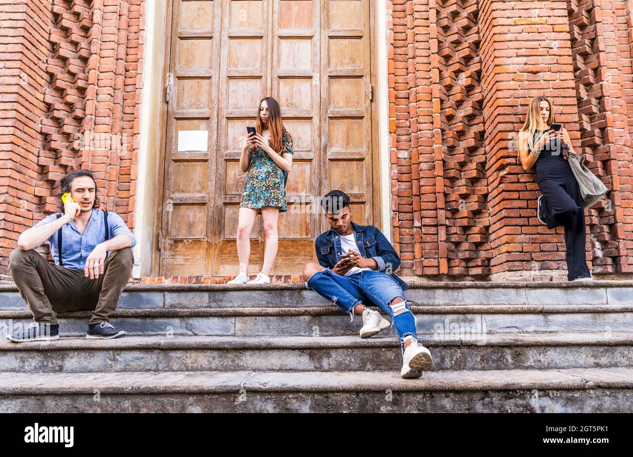Four young friends against brick wall hi-res stock photography and ...