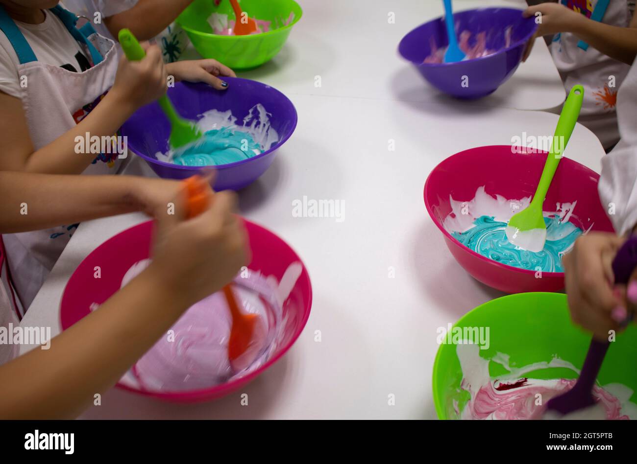 children making slime in bowls. kids hands making slime on pink ...