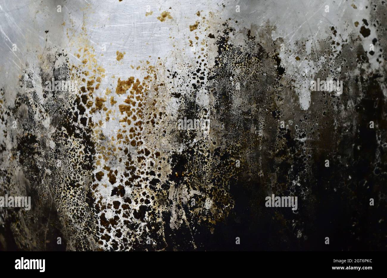 Brown and black color stain on the silver surface that has white ...