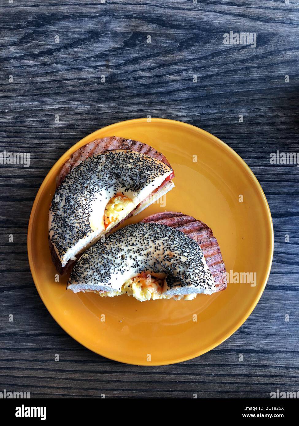Egg And Bacon Filled Poppy Seed Bagel Stock Photo - Alamy