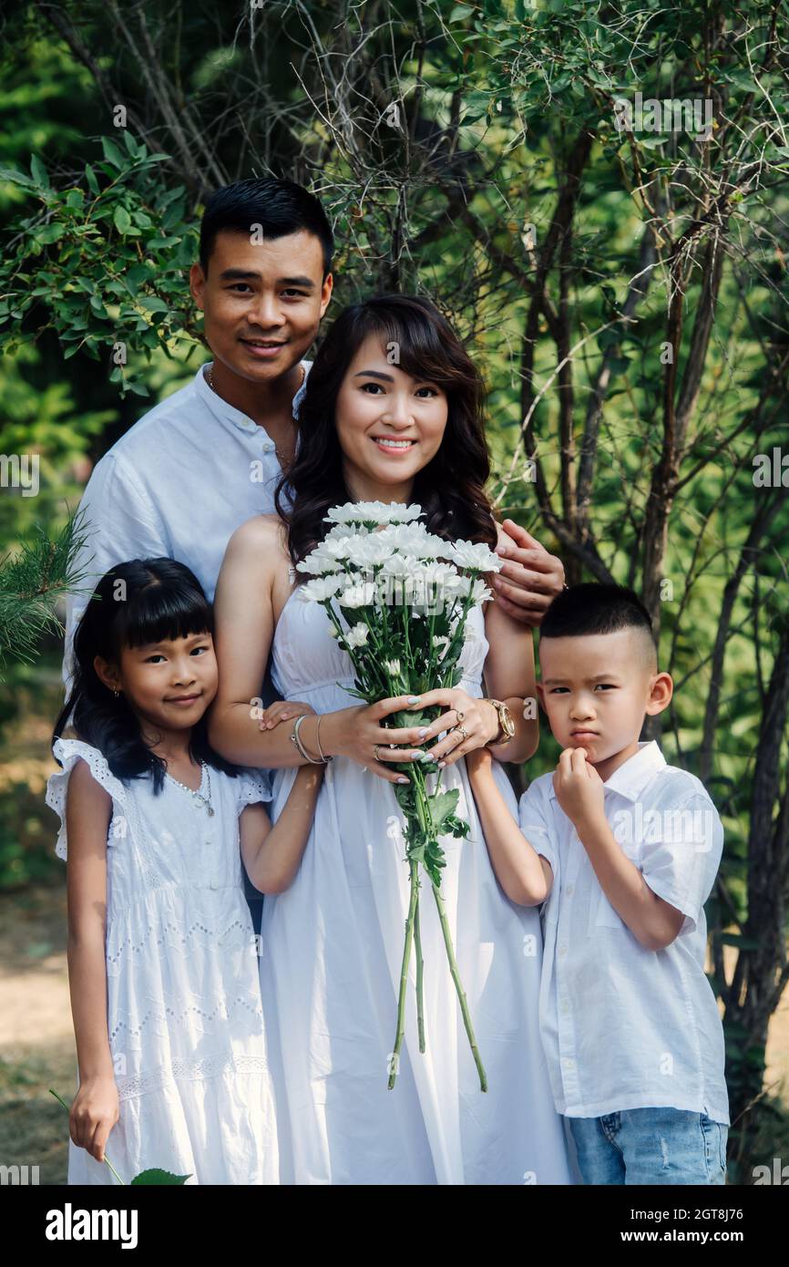 Family portrait of happy loving asian parents and their kids standing ...