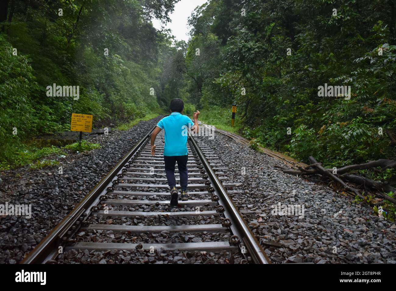 Rear View Of Boy Walking On Railroad Track Stock Photo - Alamy