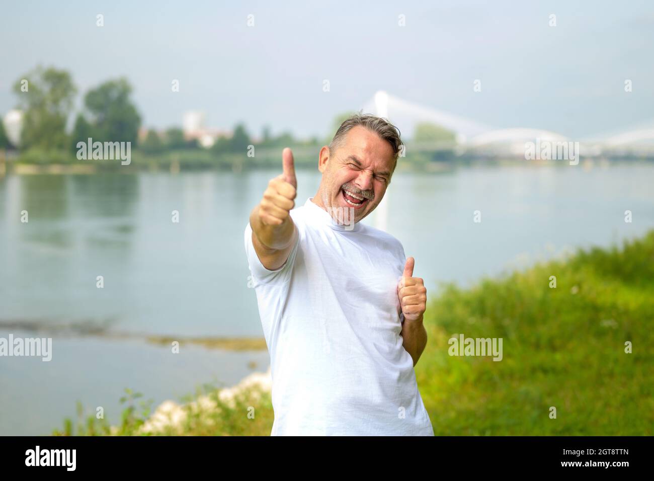 Excited exuberant man giving a triumphant thumbs up gesture with a ...