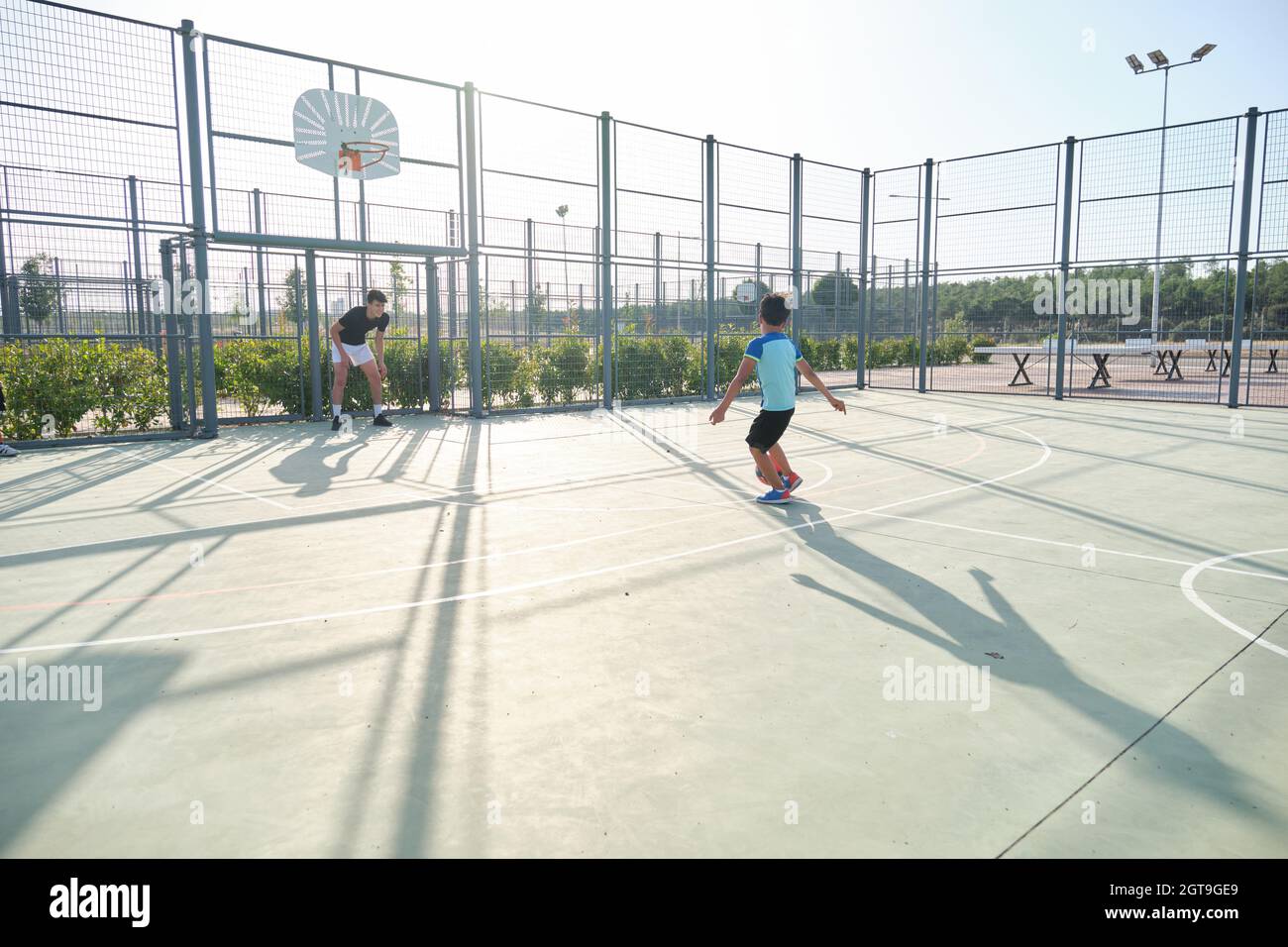 Two brothers playing football, one is the goalkeeper and other kicks a ...