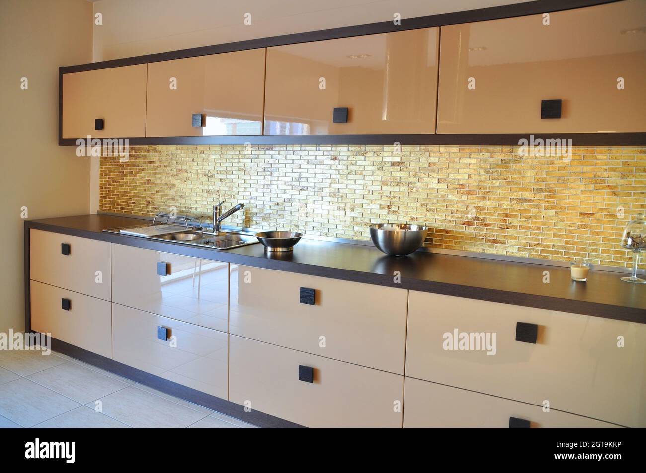 Interior of luxurious modern kitchen equipment, beige lacquer cabinets ...