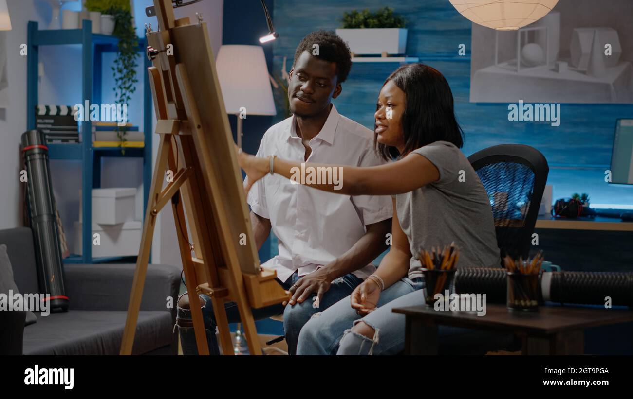 Young artists of african american ethnicity drawing on canvas with ...