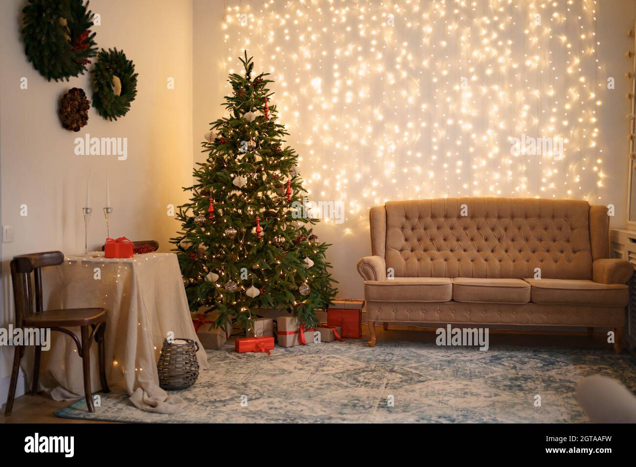 Festive interior with comfortable sofa and decorated Christmas tree ...