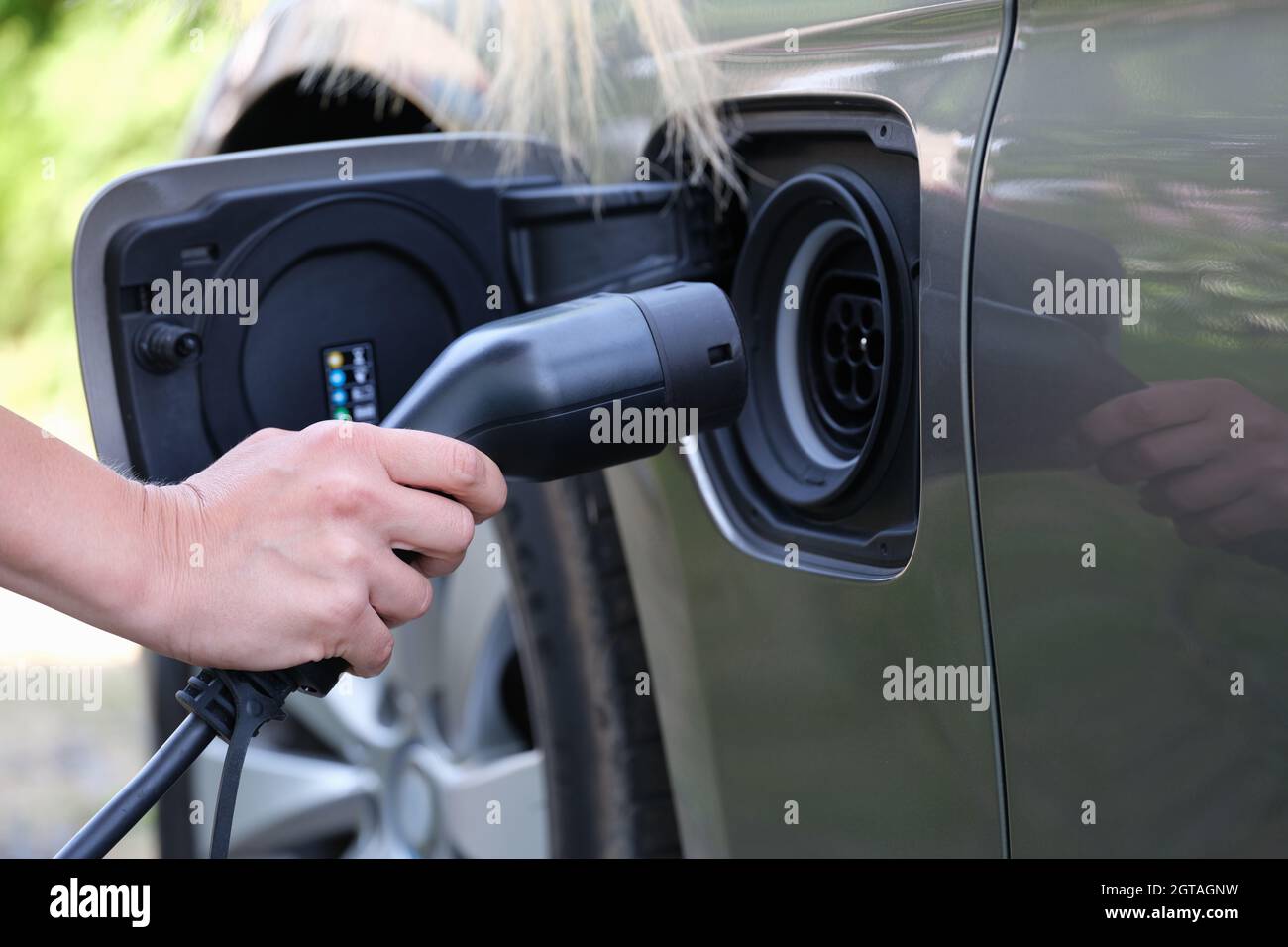 Female hand inserts plug for charging electric car closeup Stock Photo ...