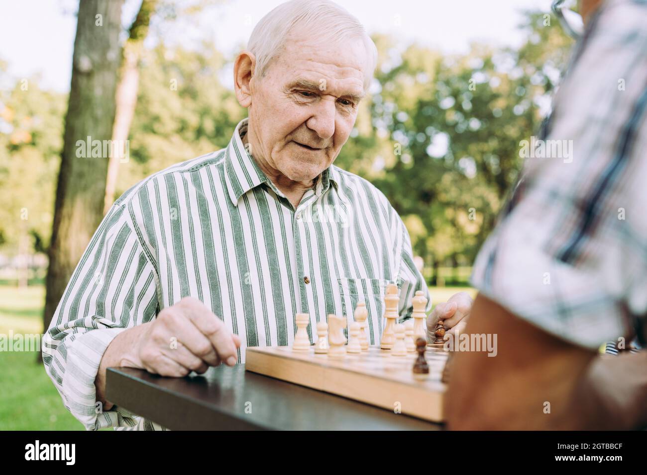Group of senior friends playing chess game at the park. Lifestyle ...