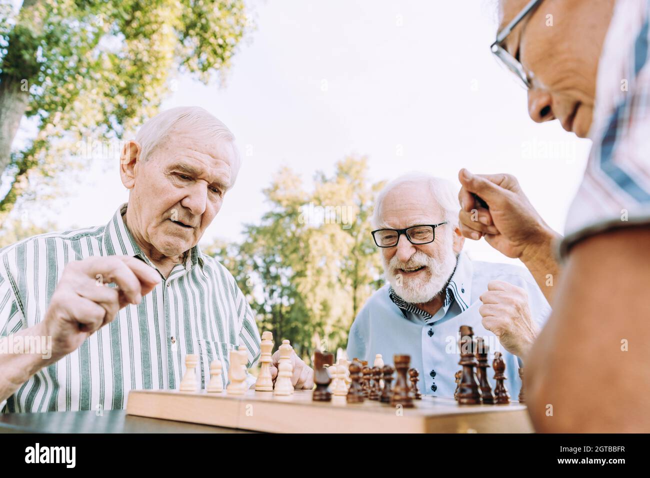Group of senior friends playing chess game at the park. Lifestyle ...