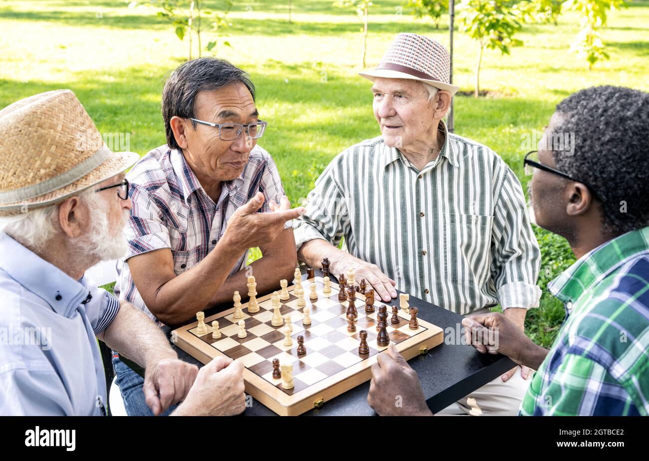 Group of senior friends playing chess game at the park. Lifestyle ...
