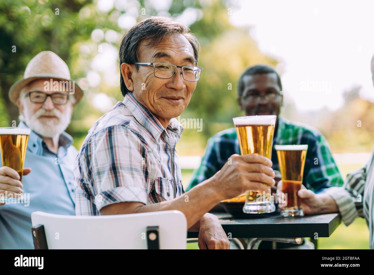 group of senior friends drinking a beer at the park. Lifestyle concepts ...