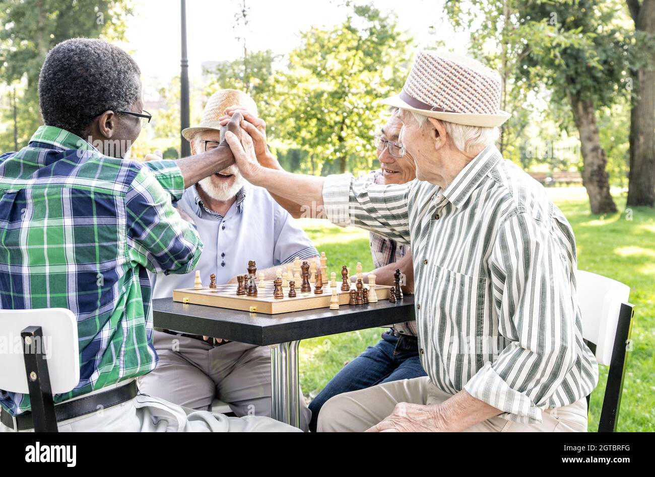 Group of senior friends playing chess game at the park. Lifestyle ...