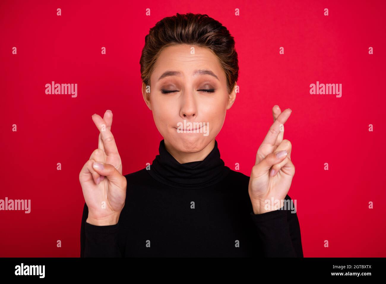 Photo of young happy nervous woman hold fingers crossed nervous worried ...