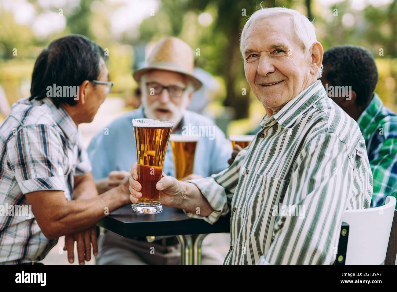 group of senior friends drinking a beer at the park. Lifestyle concepts ...