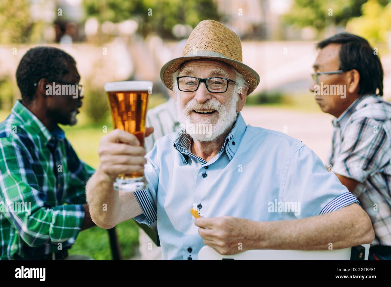 group of senior friends drinking a beer at the park. Lifestyle concepts ...