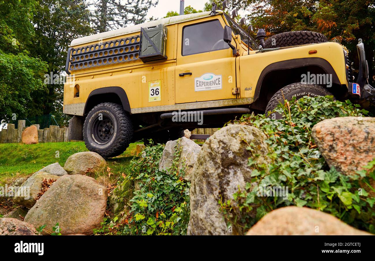 Land Rover Defender, classic English off-road vehicle on round granite ...
