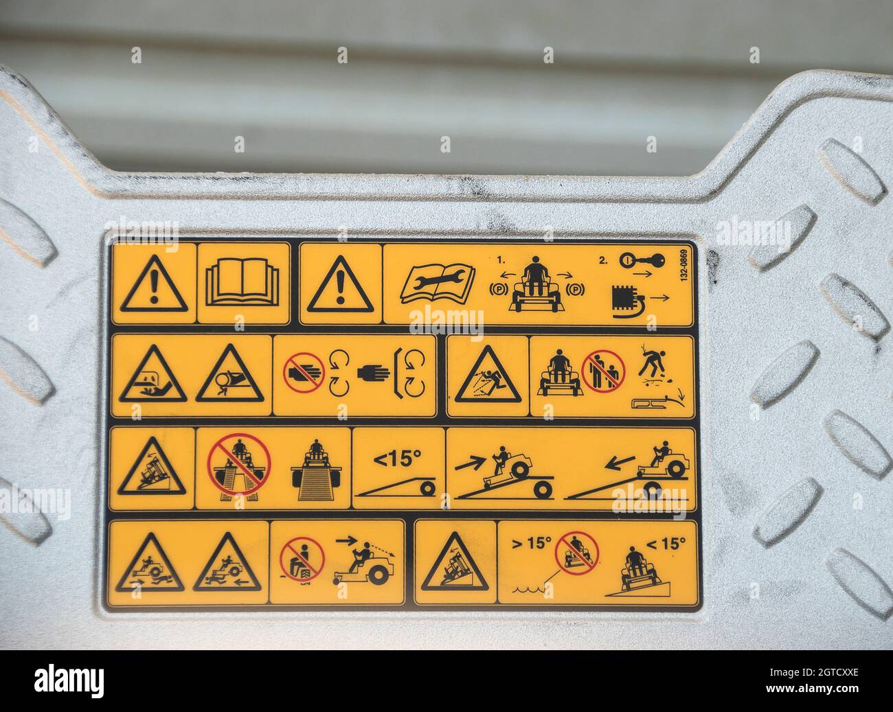 Warning diagrams attached to metal foot-plate of new ride-on lawn mower ...