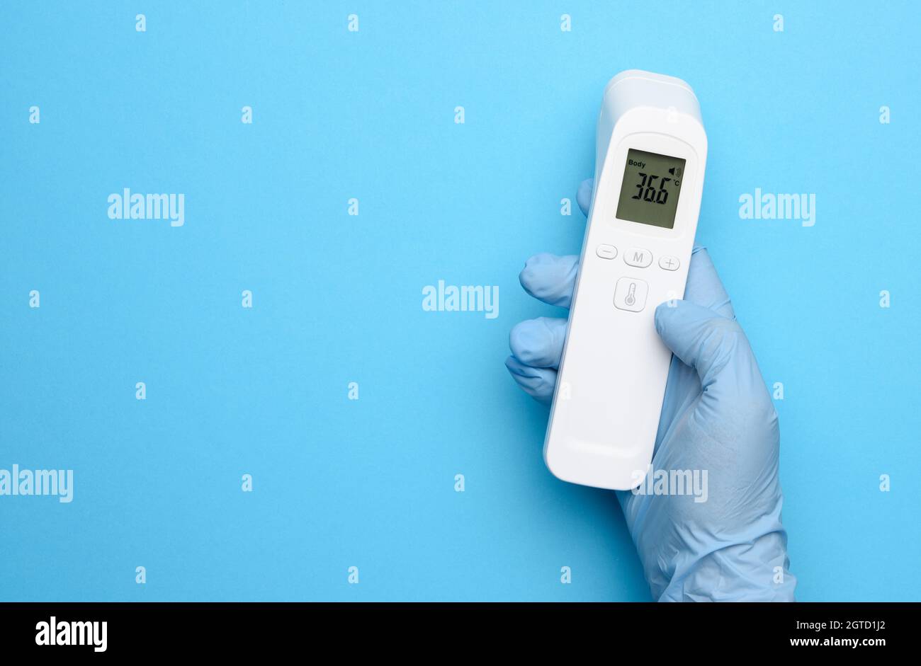 Hand In Blue Latex Gloves Hold An Electronic Thermometer To Measure ...