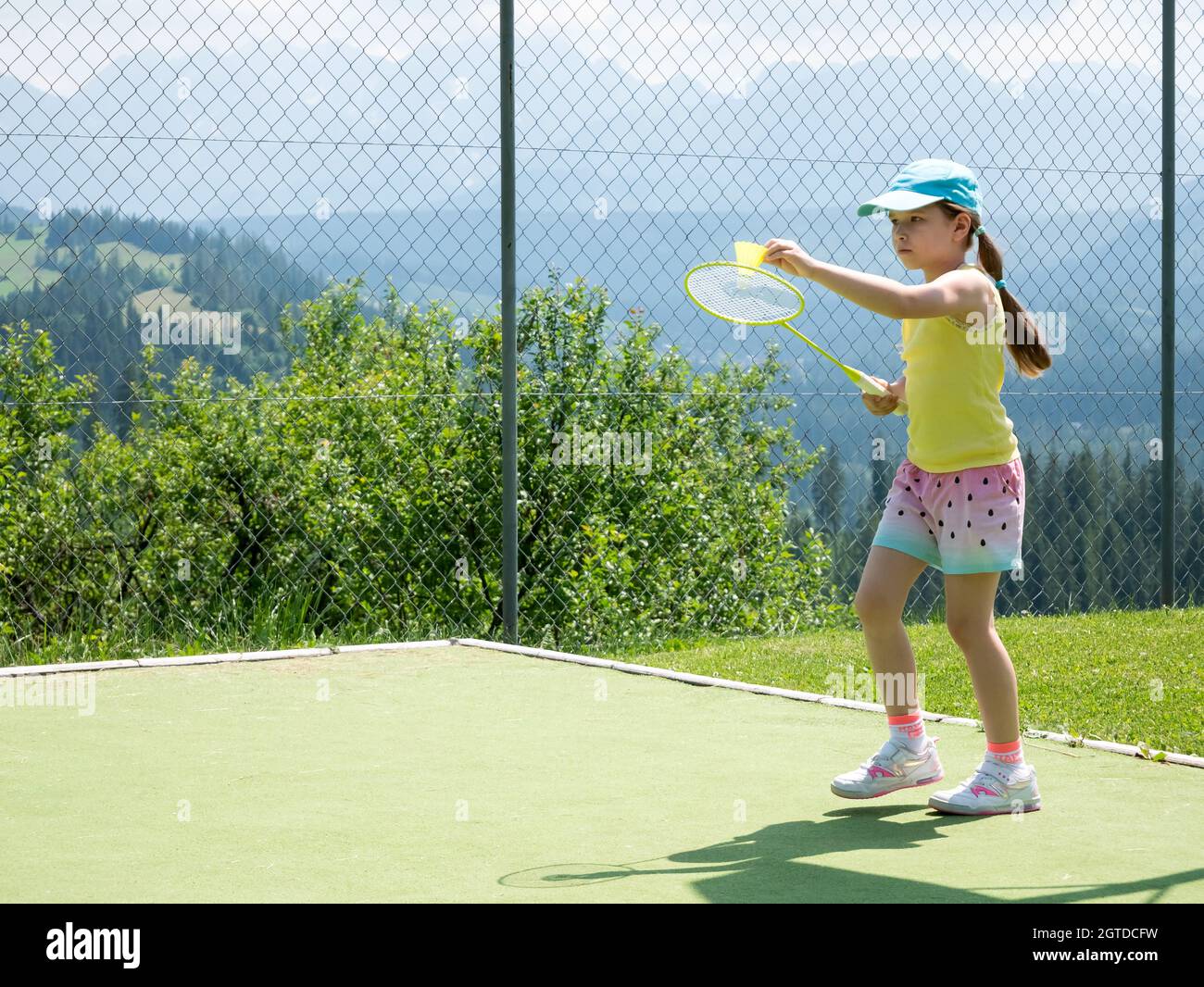 One young school age child, little girl playing badminton outside ...