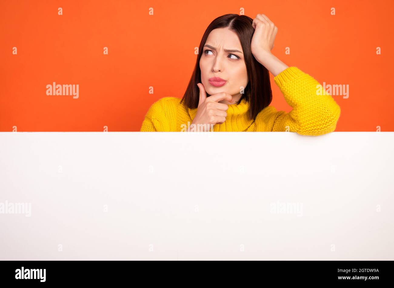 Photo of young woman hand touch chin think look empty space advert ...