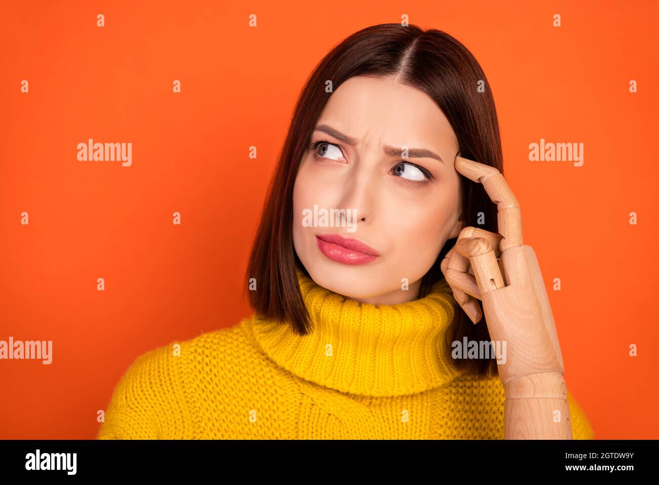 Photo of young woman finger touch head wooden prosthesis thoughtful ...