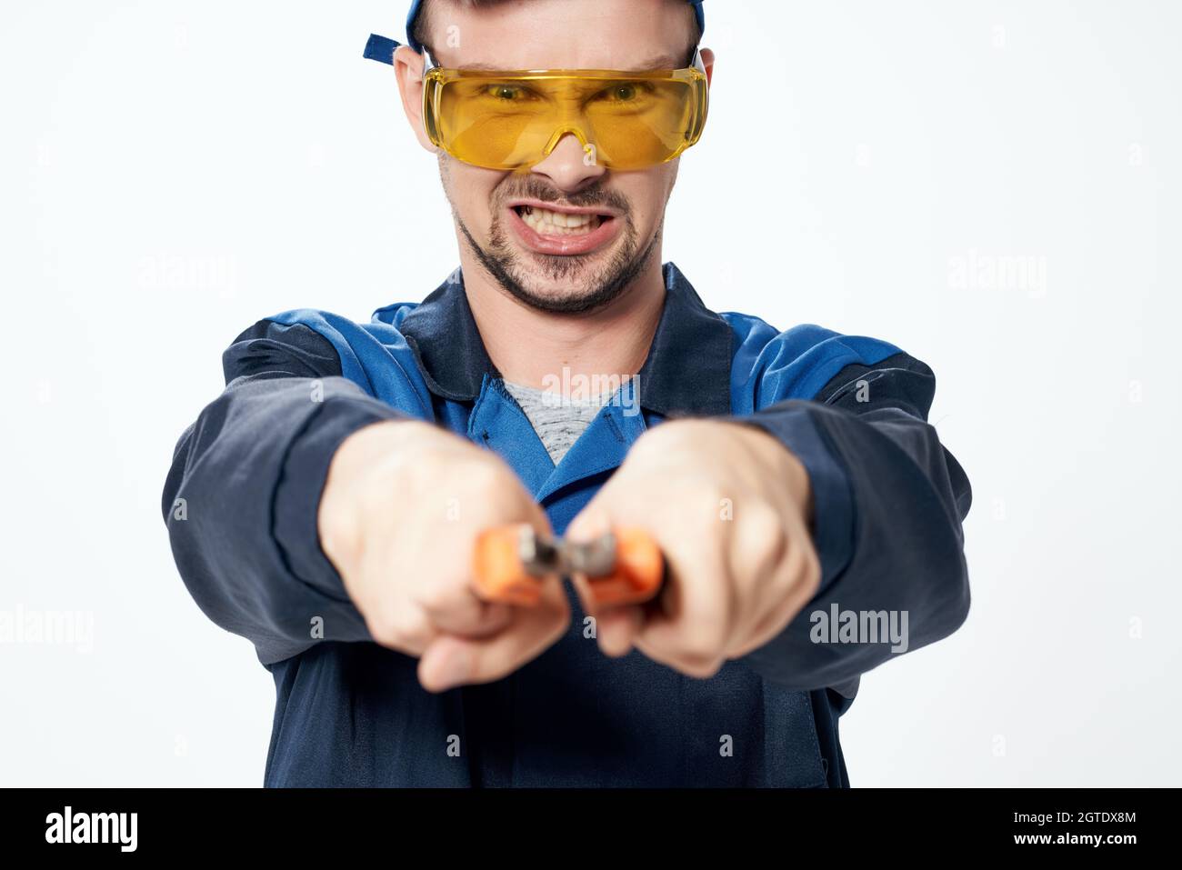 male builder in yellow construction glasses emotions light background ...