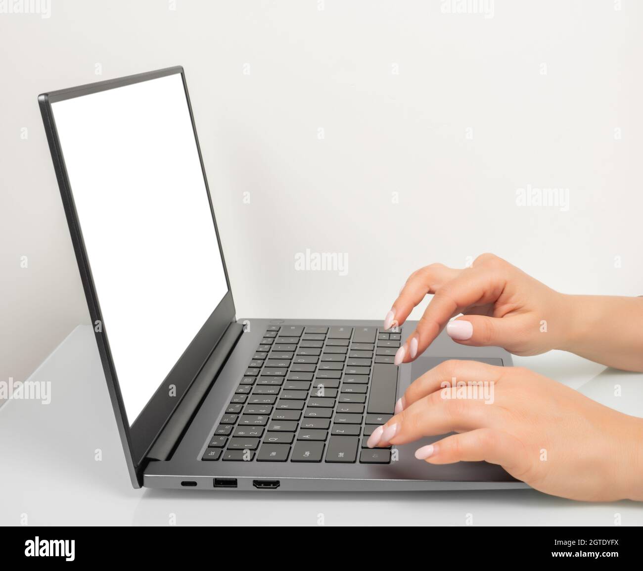 Business woman hands using mockup laptop with white blank screen. side ...