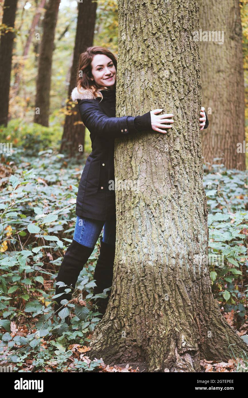Young woman hugging tree in woodland hi-res stock photography and ...