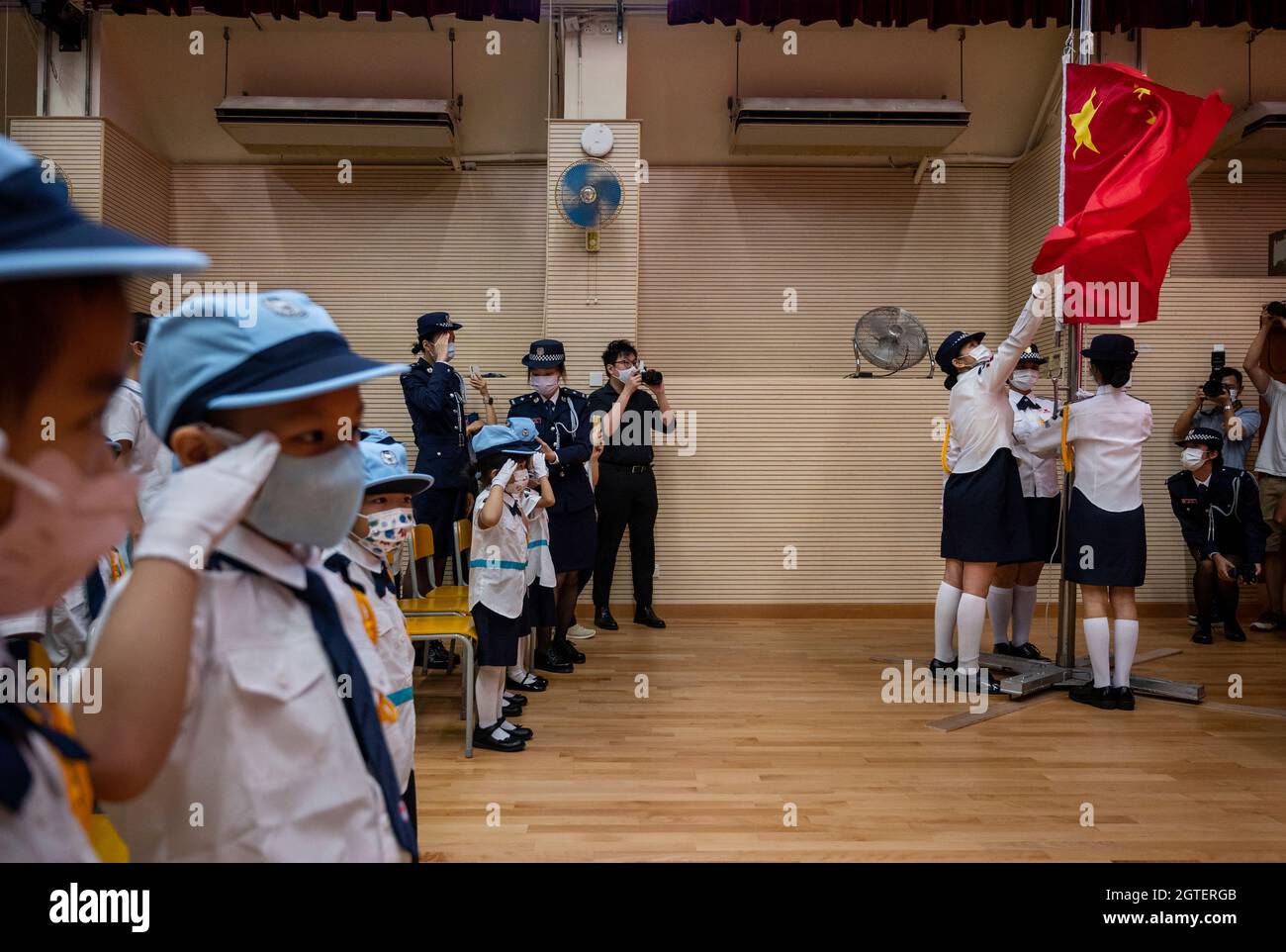Students salute while watching the flag-raising ceremony to commemorate ...