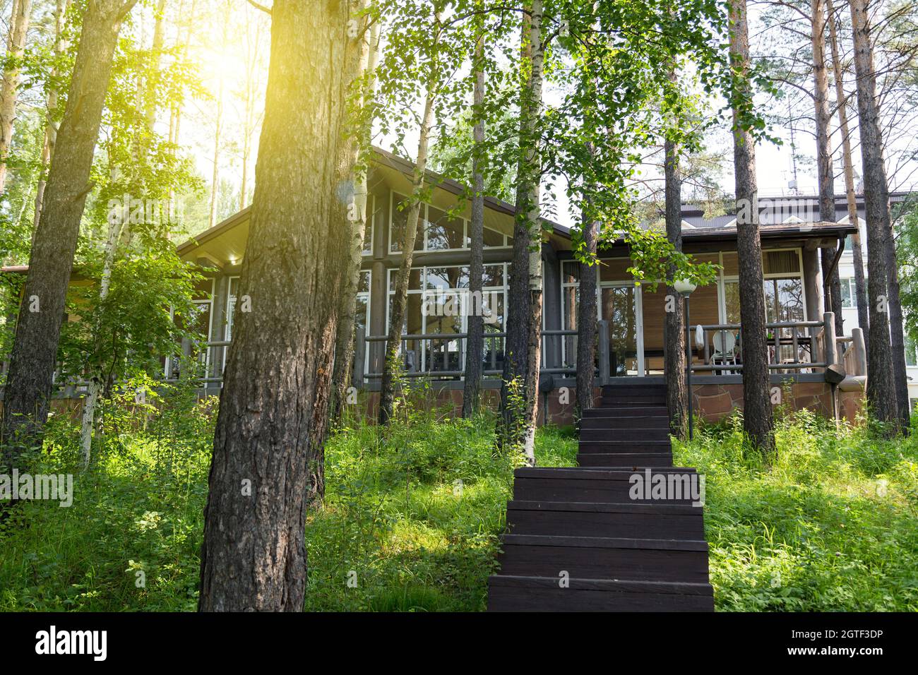 path in the forest leading to beautiful wooden hotel Stock Photo - Alamy