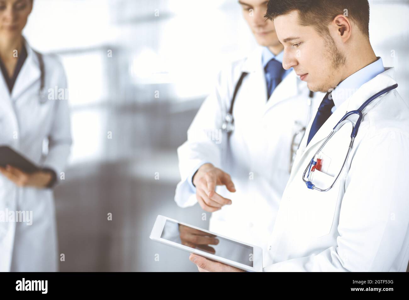 Group of doctors are checking medical names on a computer tablet, with ...
