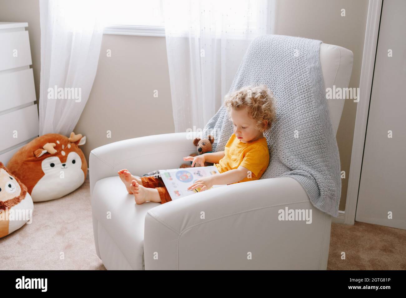 Kid reading book bed home barefoot hi-res stock photography and images ...