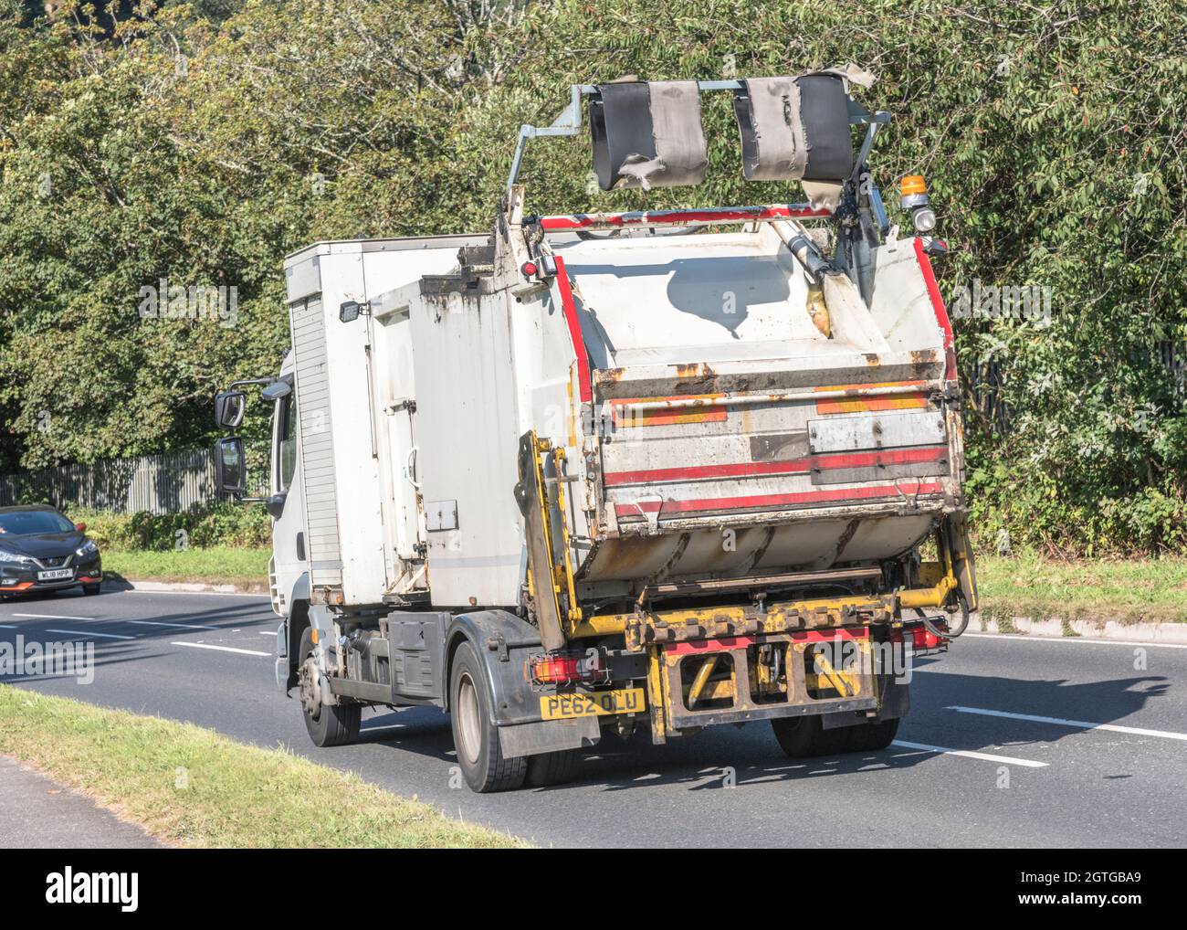 Unidentified white waste management truck travelling downhill on ...