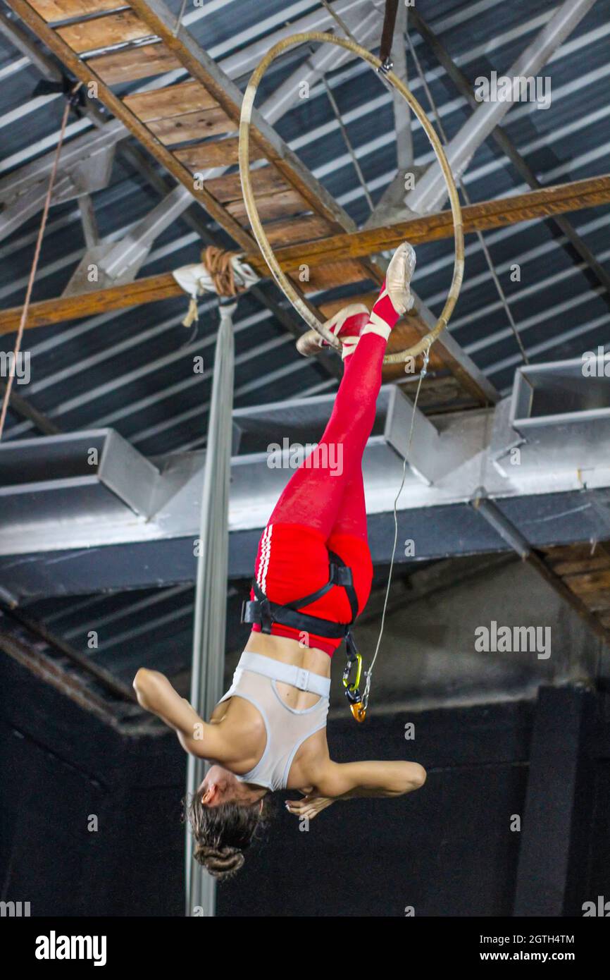 Young female aerial acrobat practicing on a hoop Stock Photo - Alamy