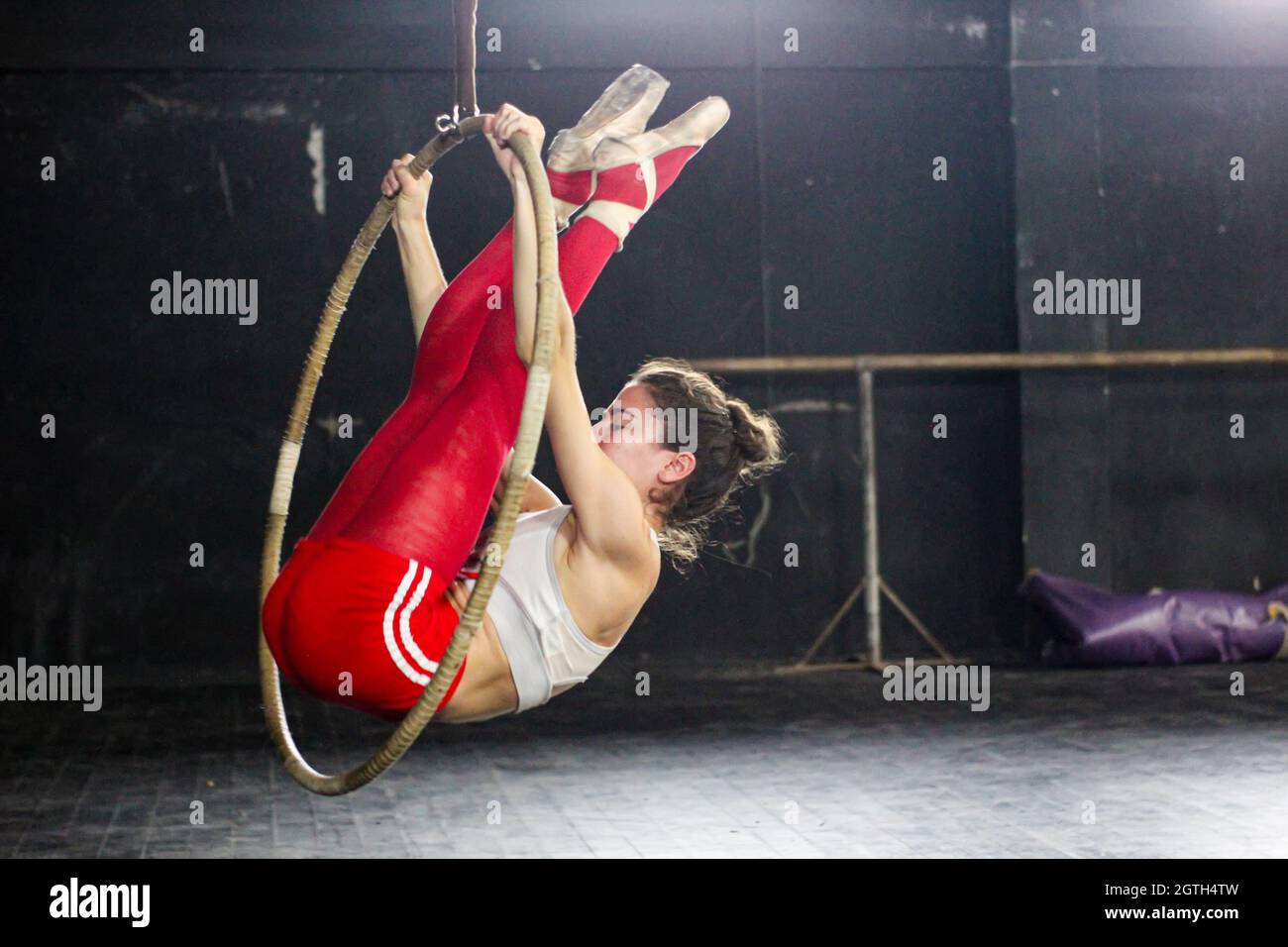 Young female aerial acrobat practicing on a hoop Stock Photo - Alamy