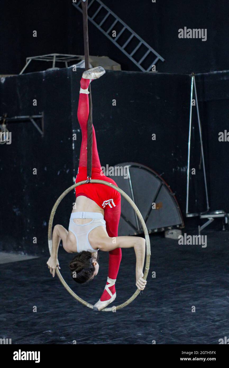 Young female aerial acrobat practicing on a hoop Stock Photo - Alamy
