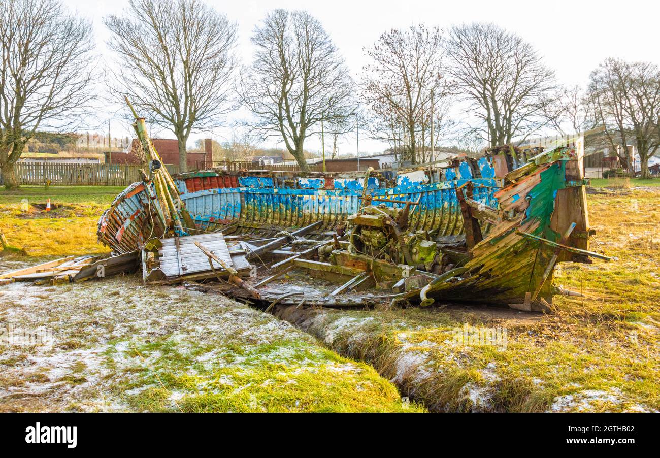 Abandoned wooden ship wreck on frost covered grass on the Dee estuary ...