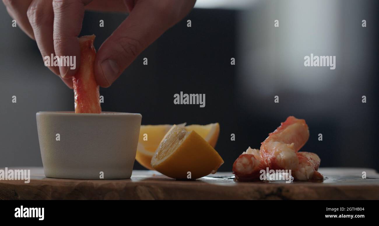 man eating crab with dip sauce, wide photo Stock Photo - Alamy