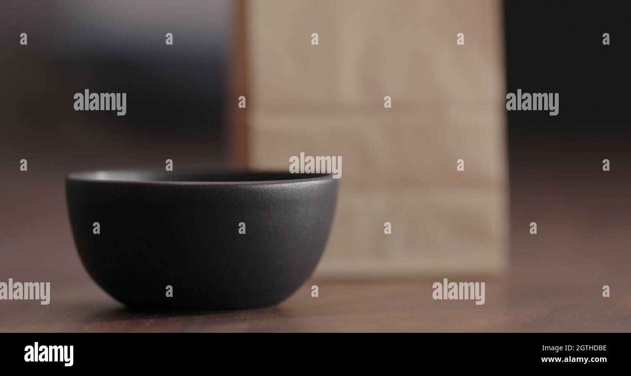 Black empty ceramic bowl on walnut table, wide photo Stock Photo - Alamy