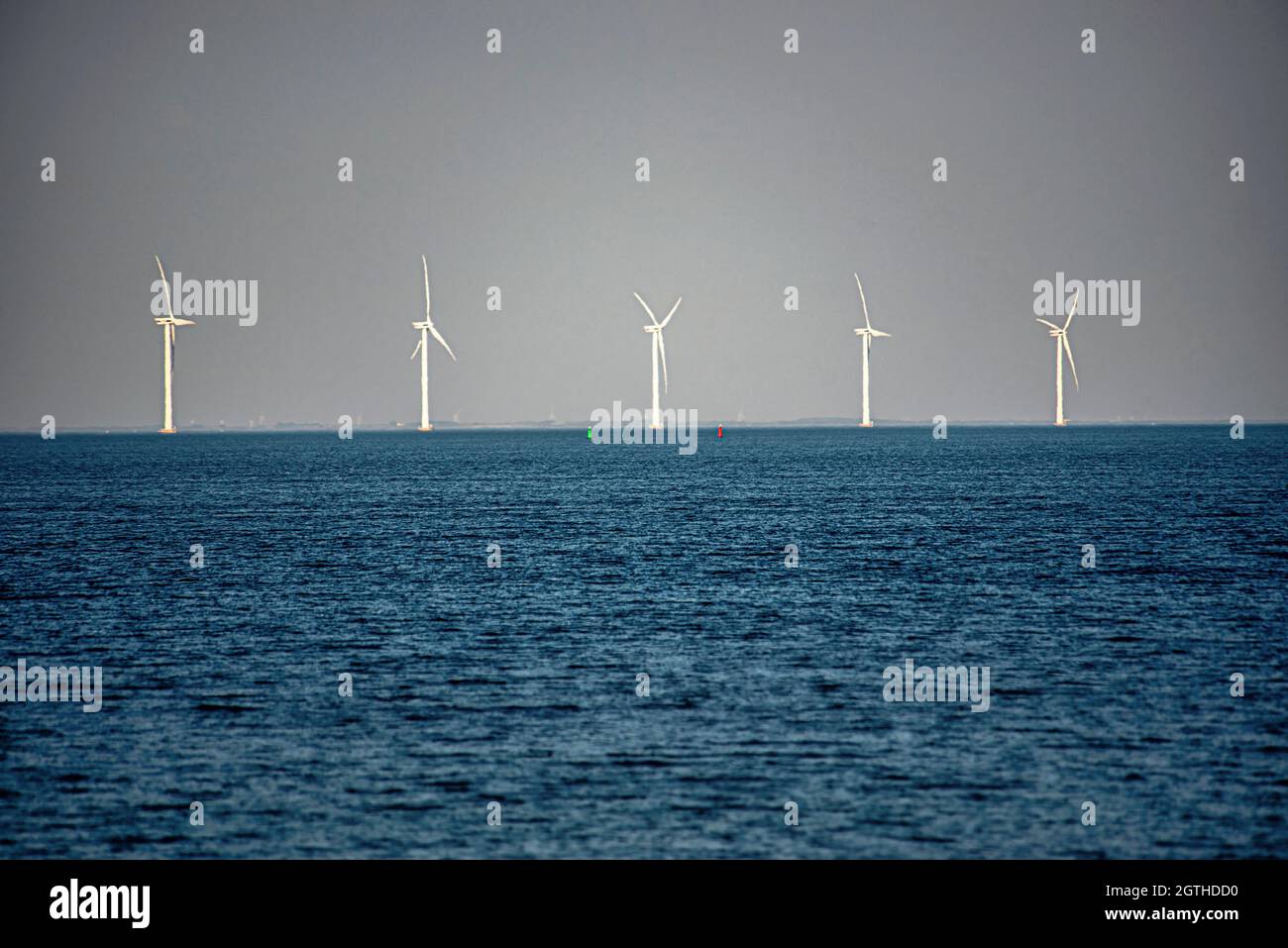 wind power farm in the North Sea. offshore windfarm against a clear sky ...
