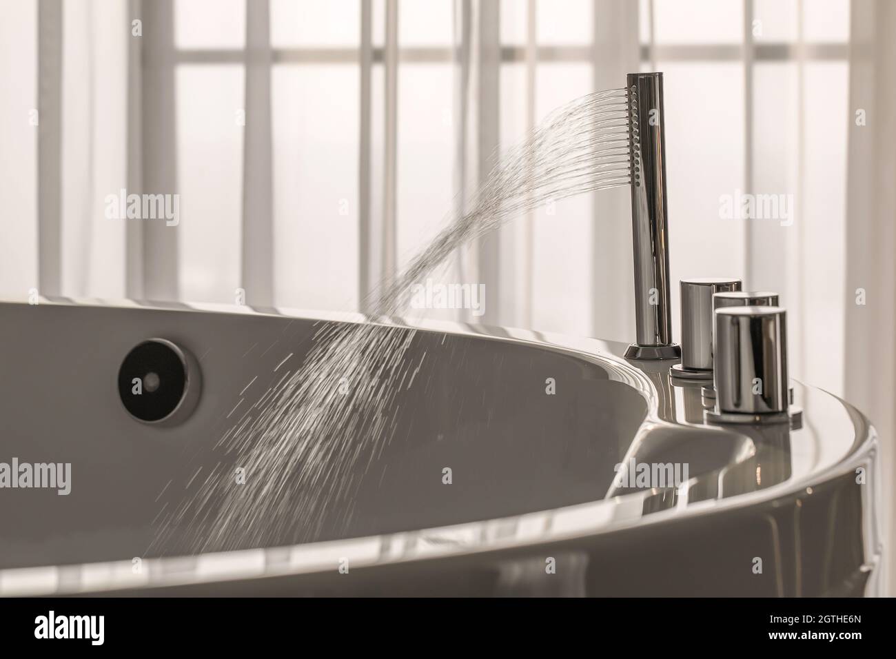 Spout running water from wide bath tube faucet into a hot Jacuzzi Stock ...
