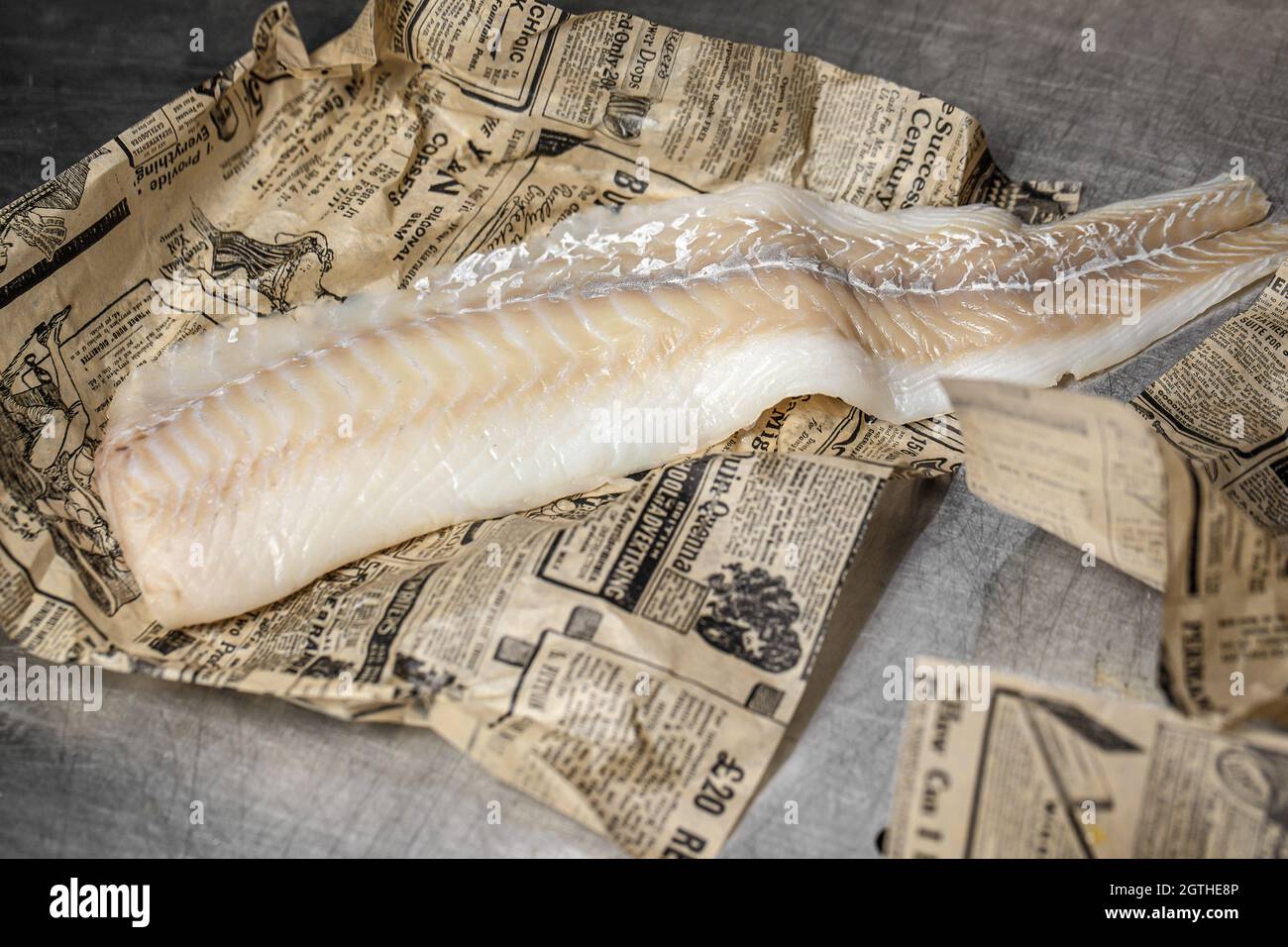 Fresh raw cod fillet on newspaper ready for cooking Stock Photo - Alamy